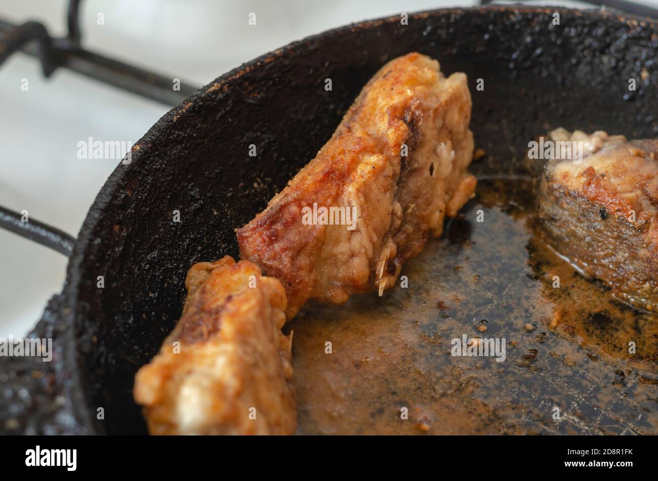Portions of fish fried to golden crust in frying pan. Fried fish with ...