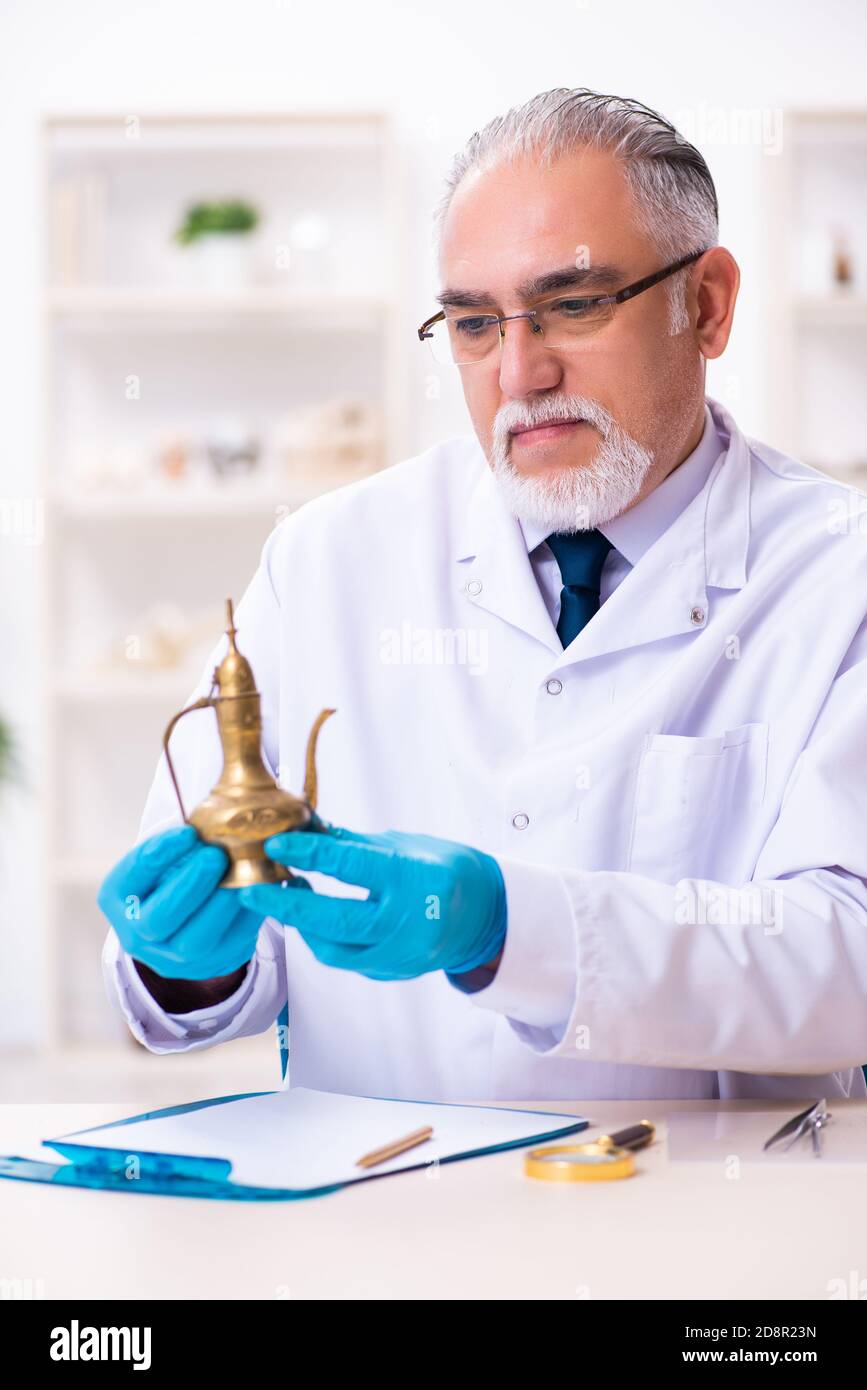 Old male archaeologist working in the lab Stock Photo - Alamy