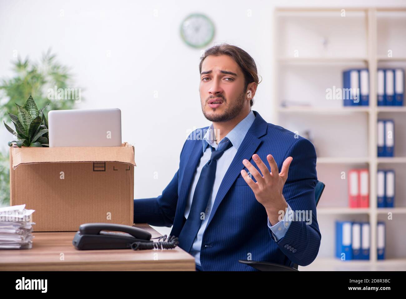 Young man being fired from his workplace Stock Photo - Alamy