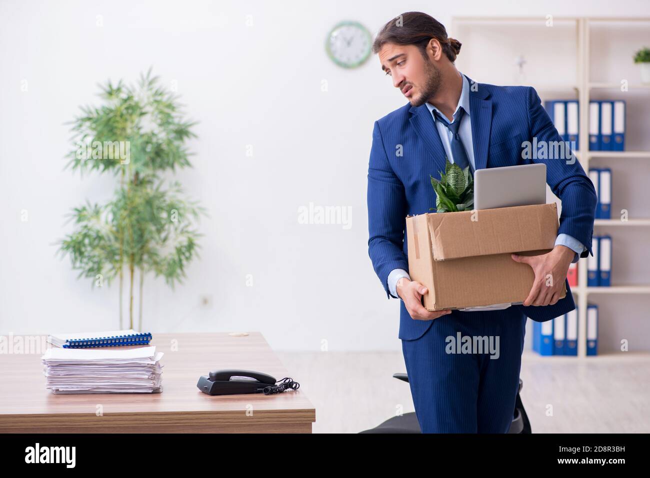 Young man being fired from his workplace Stock Photo - Alamy