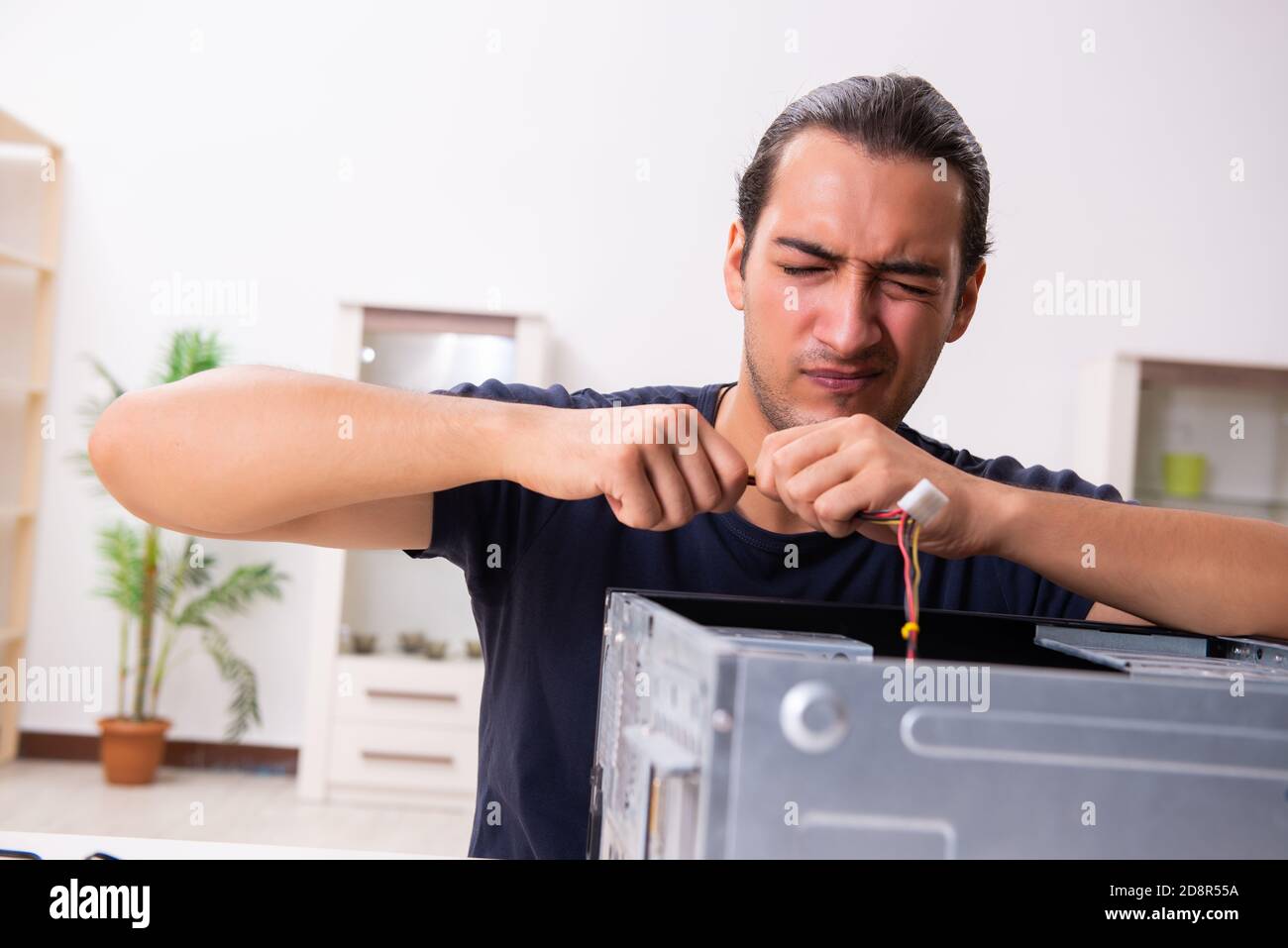 Young man repairing computer at the home Stock Photo - Alamy