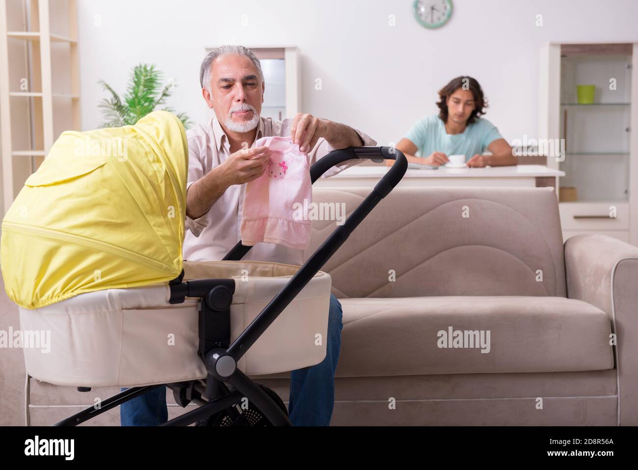 Old grandfather looking after newborn at home Stock Photo - Alamy