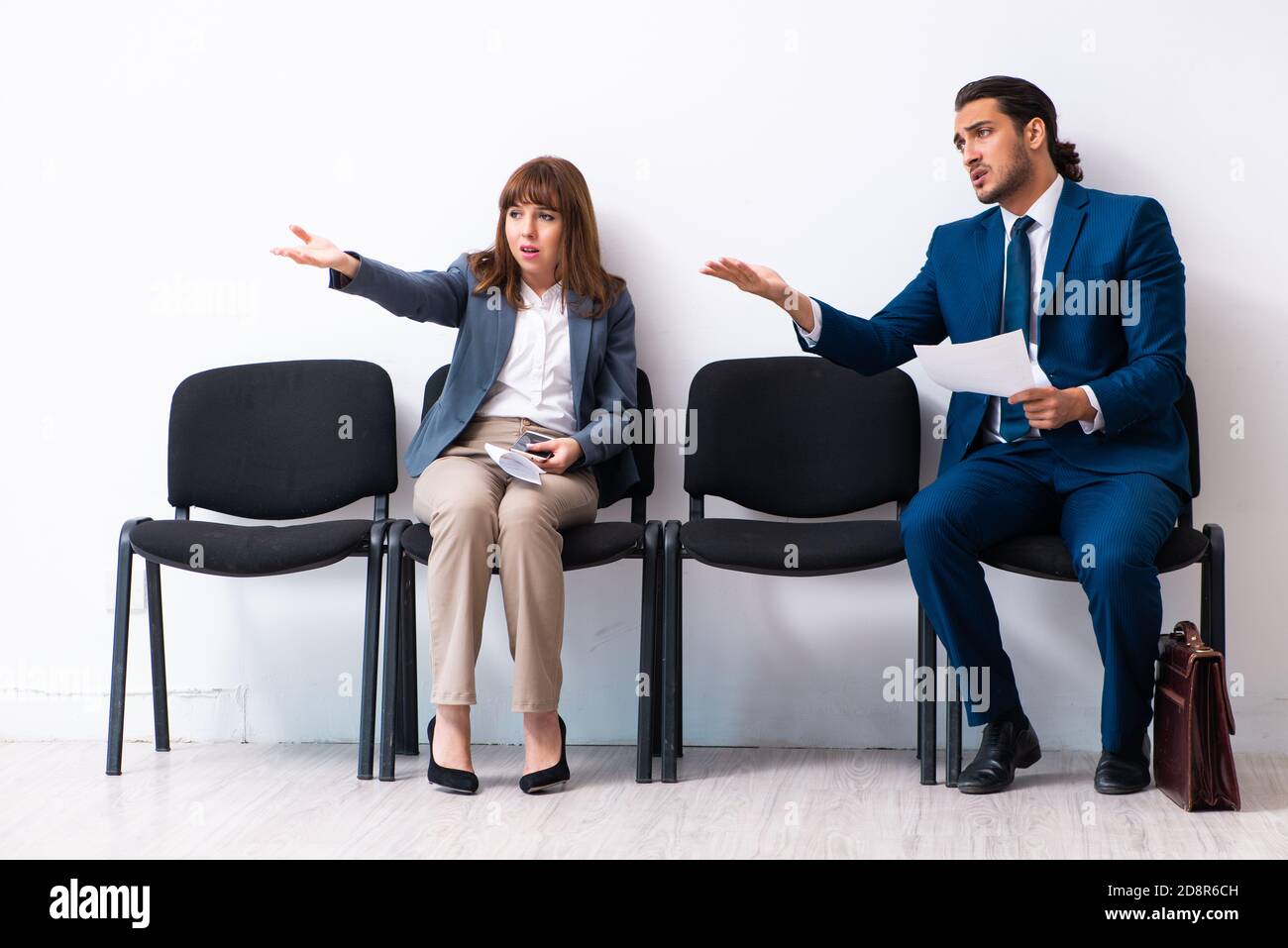 Businessman and businesswoman waiting for an interview at hall Stock ...