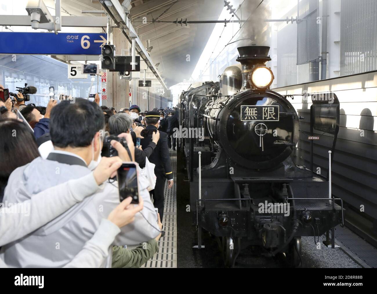 People take photos of a special train featuring a movie of the popular ...