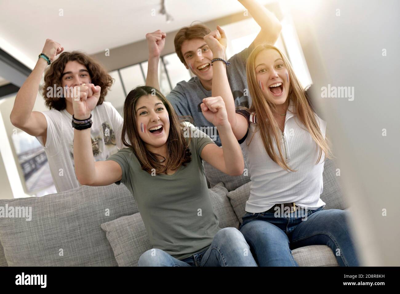 Group of friends cheering up as watching game on TV Stock Photo - Alamy