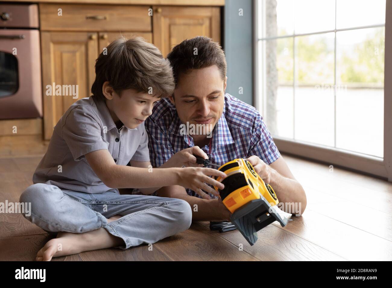 Loving dad and small son repair toy car together Stock Photo - Alamy