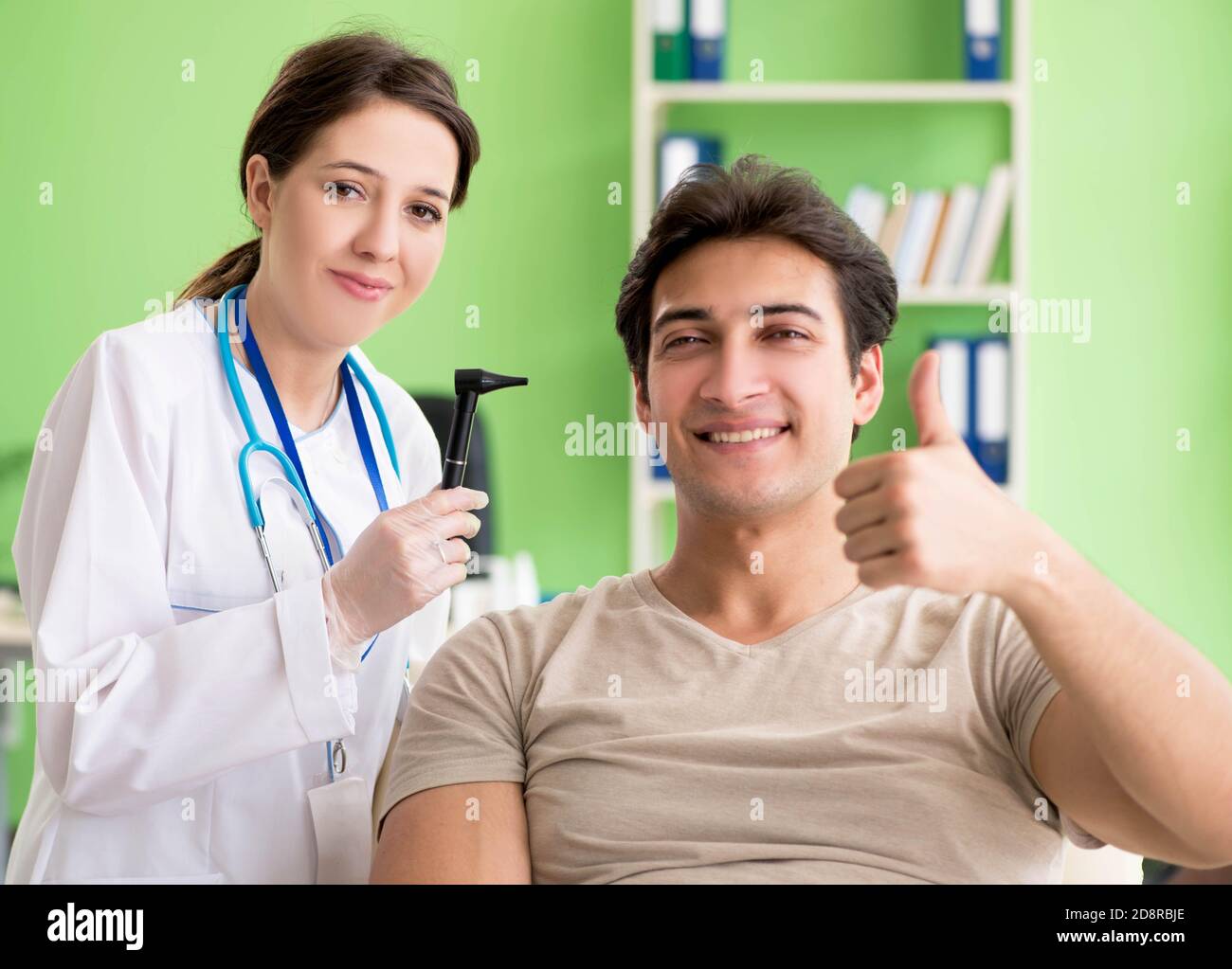 The female doctor checking patient's ear during medical examination ...
