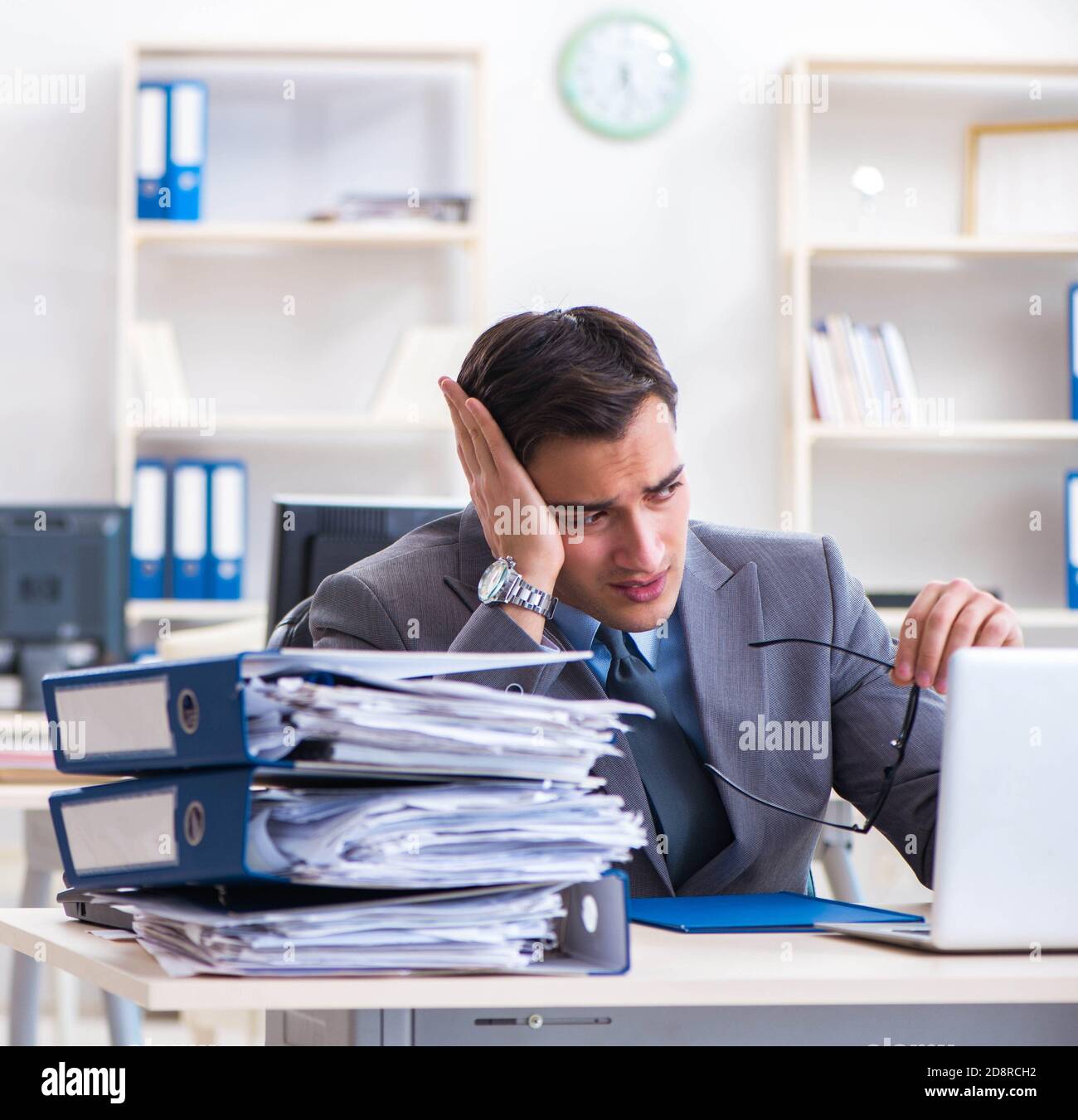 The overloaded with work employee under paperwork burden Stock Photo ...