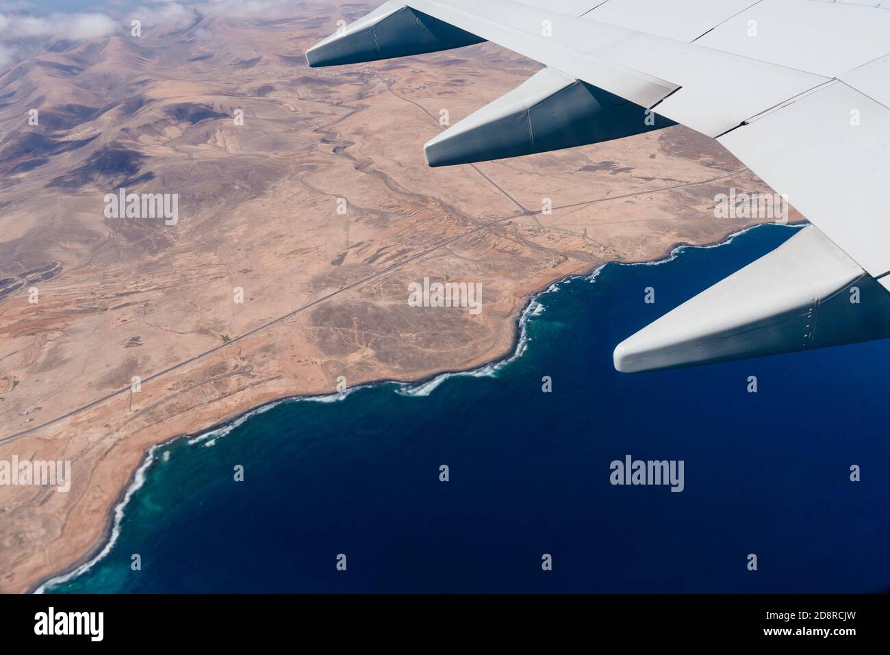 Aerial view of an airplane flying over a landscape with an ocean Stock ...