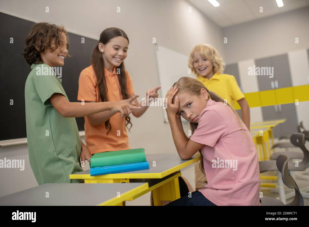 A girl in pink tshirt suffering from classmates' bullying Stock Photo ...