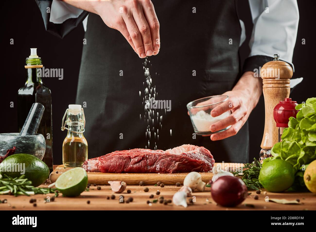 Man sprinkles salt over meat. Chef cooking a beef steak Stock Photo - Alamy
