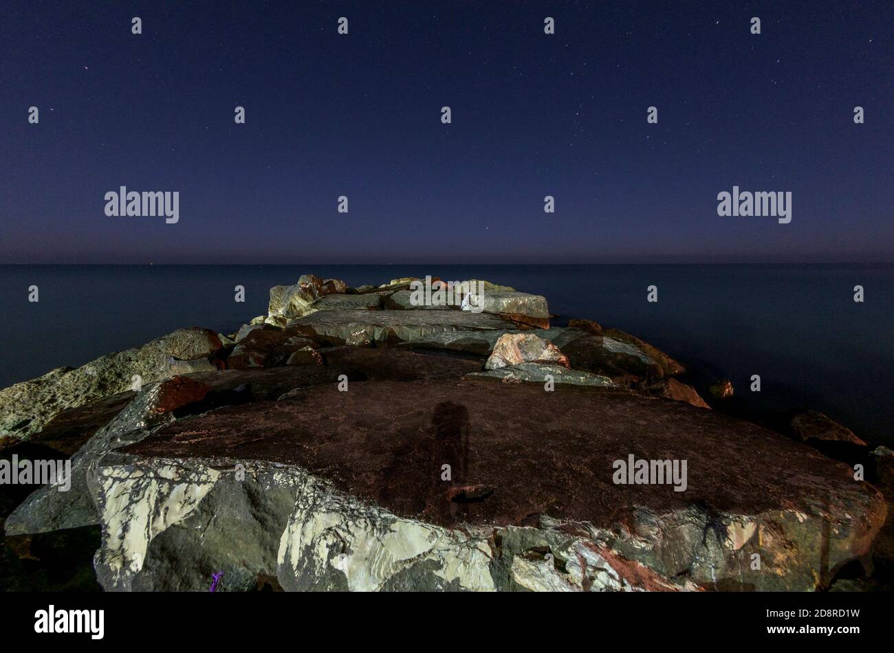 Sea with starry night sky seen from the cliff Stock Photo - Alamy