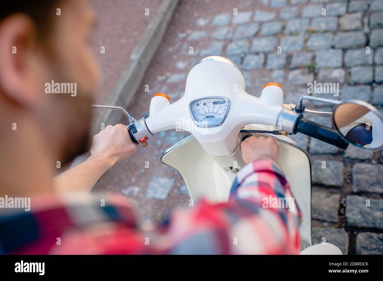 Man looking at his retro scooters speedometer Stock Photo - Alamy