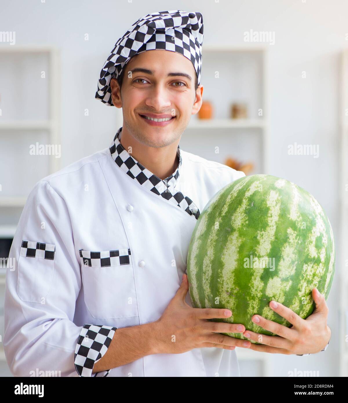The male cook with watermelon in kitchen Stock Photo - Alamy