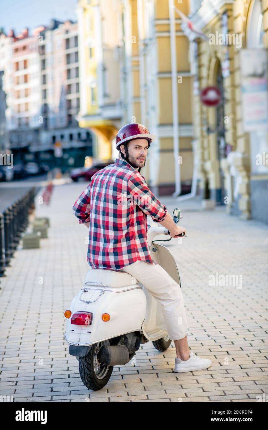 Man taking off on his white scooter Stock Photo - Alamy