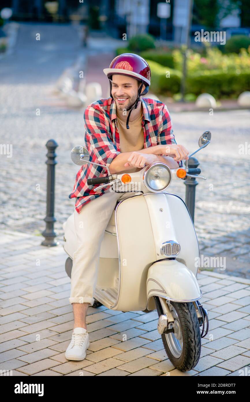 Handsome and stylish man riding a white scooter Stock Photo - Alamy
