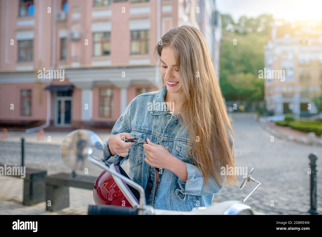Woman preparing to wear a read helmet Stock Photo - Alamy