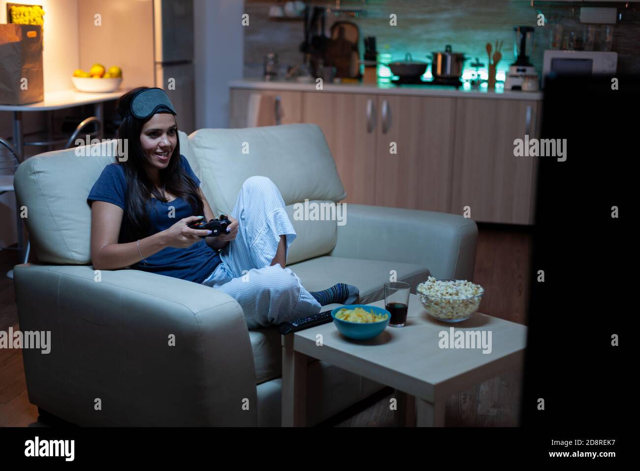 Determined woman playing video game in living room at night. Excited ...