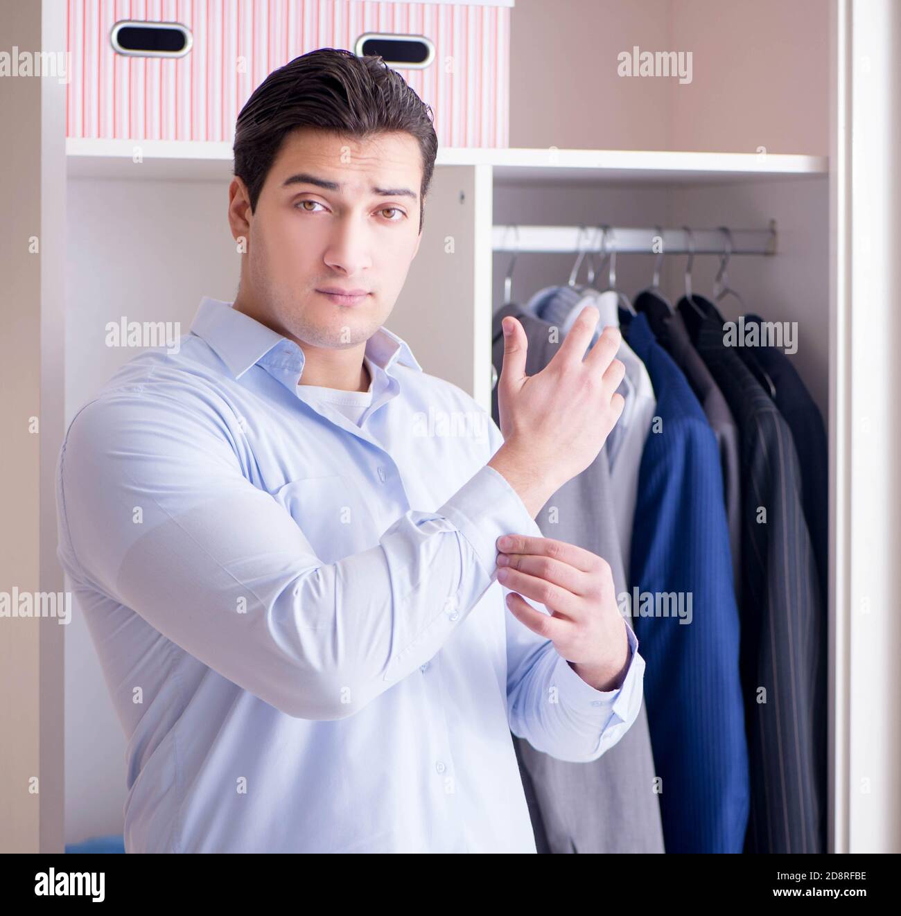 The young man businessman getting dressed for work Stock Photo - Alamy