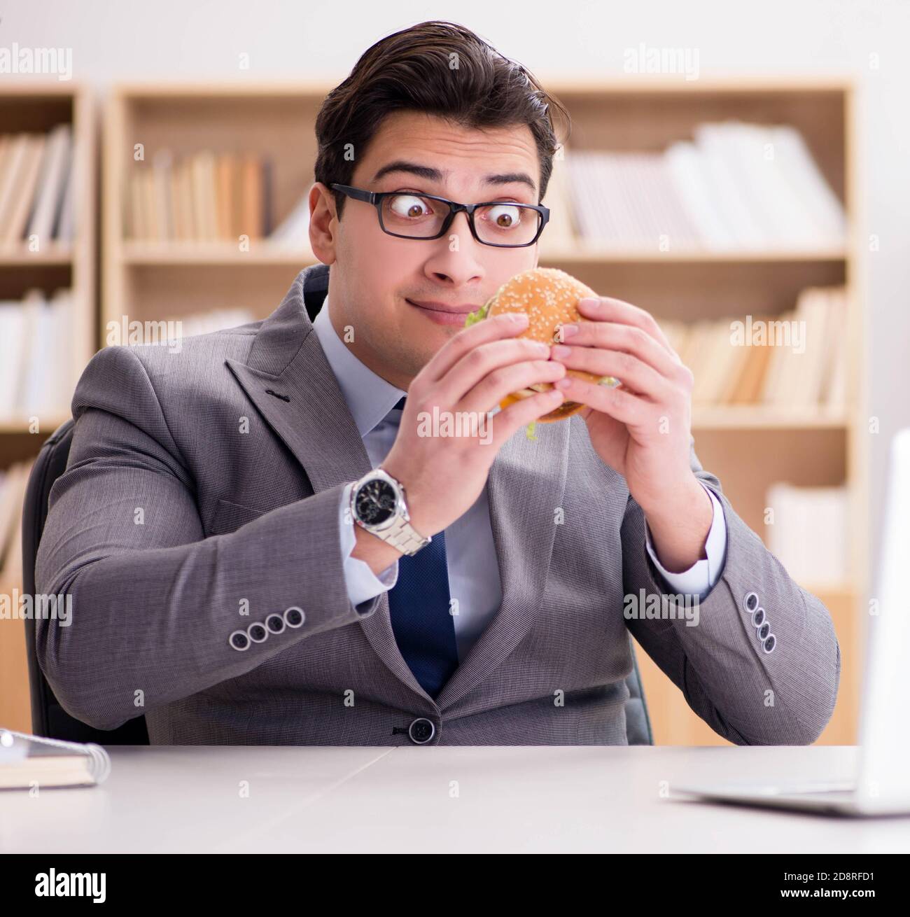 The hungry funny businessman eating junk food sandwich Stock Photo - Alamy
