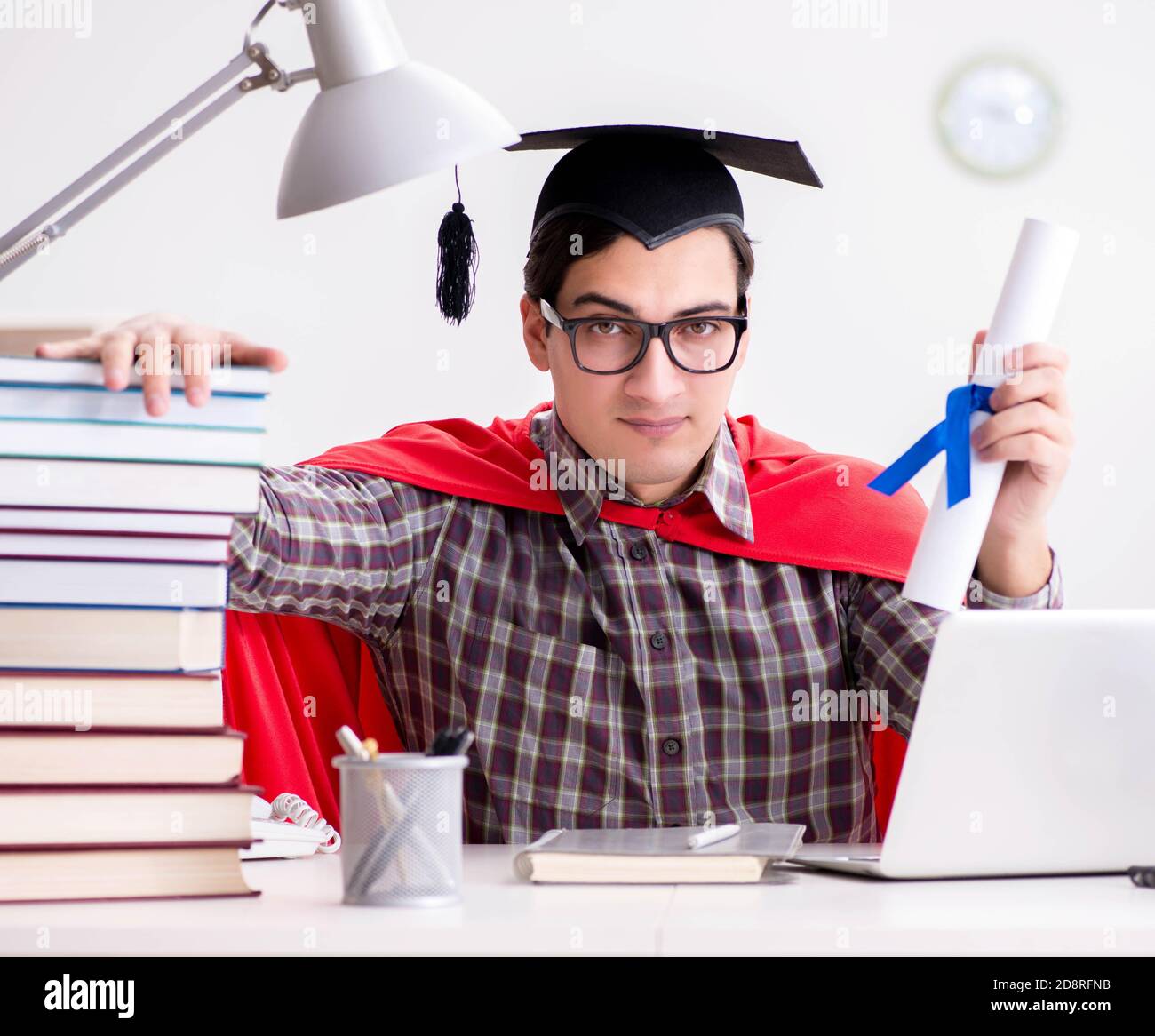 Super hero student wearing a mortarboard studying Stock Photo - Alamy