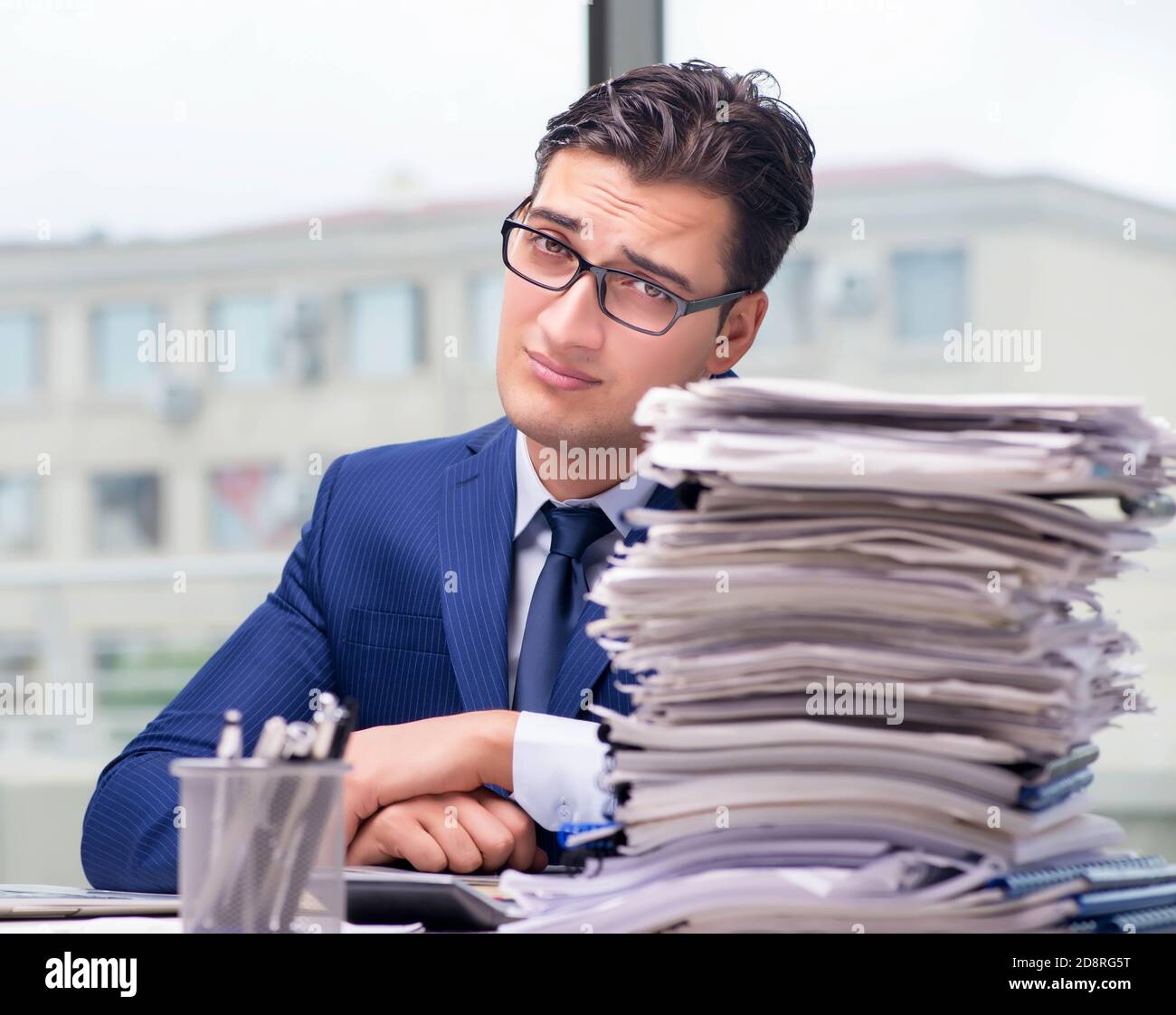 The workaholic businessman overworked with too much work in office ...