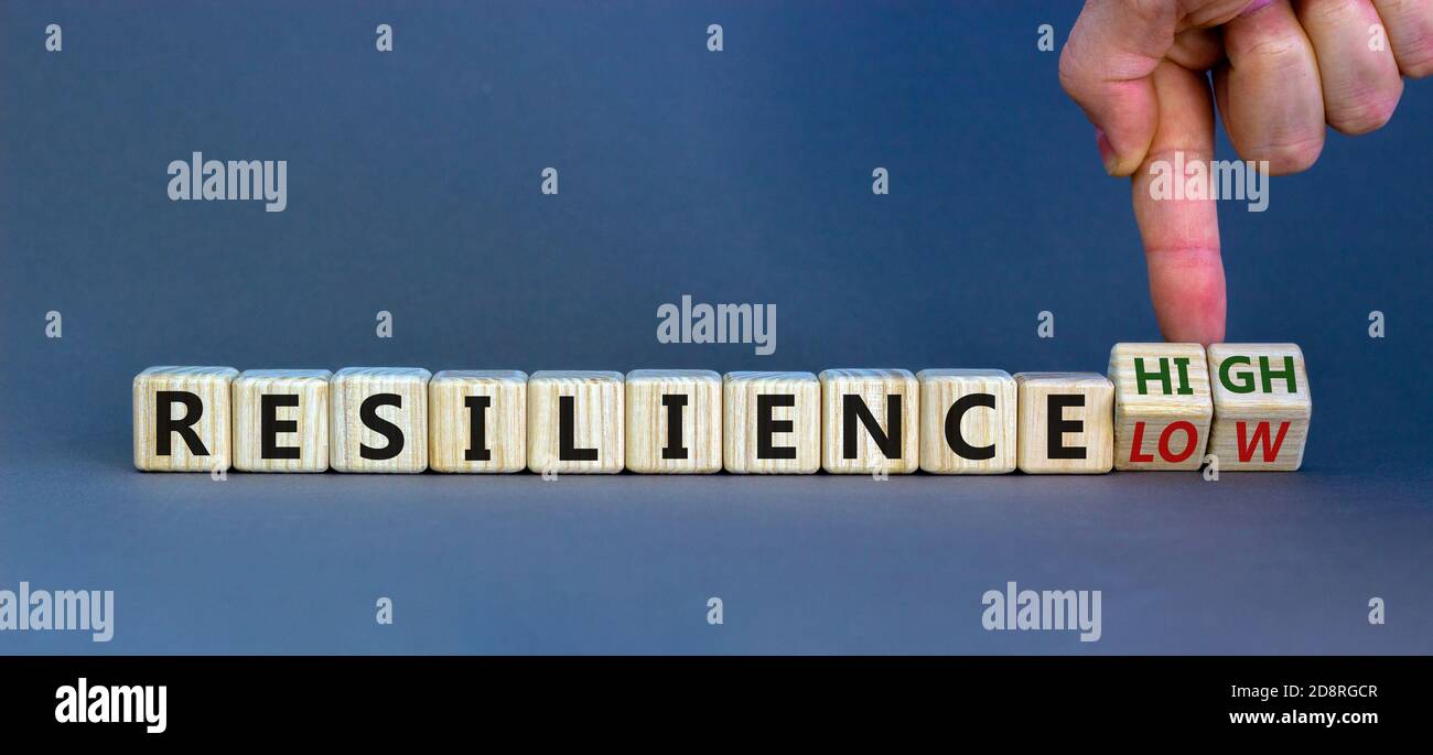 Male hand flips wooden cubes and changes the inscription 'resilience ...