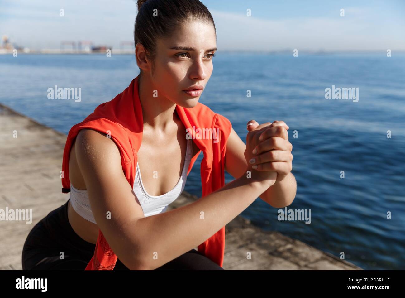 Close-up of confident and focused fitness woman looking at the sea ...