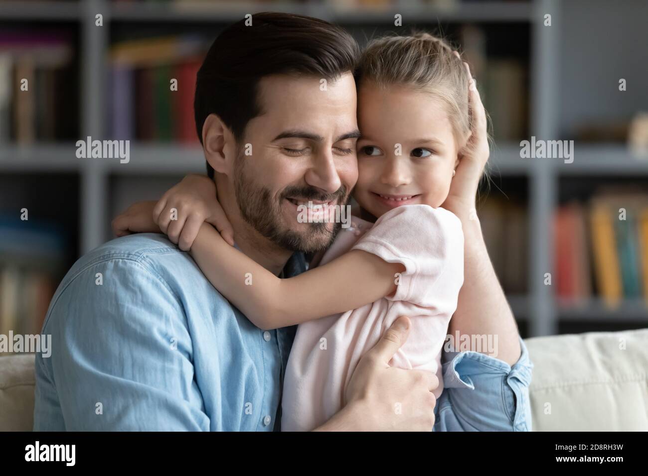 Affectionate young man cuddling cute small preschool kid daughter Stock ...