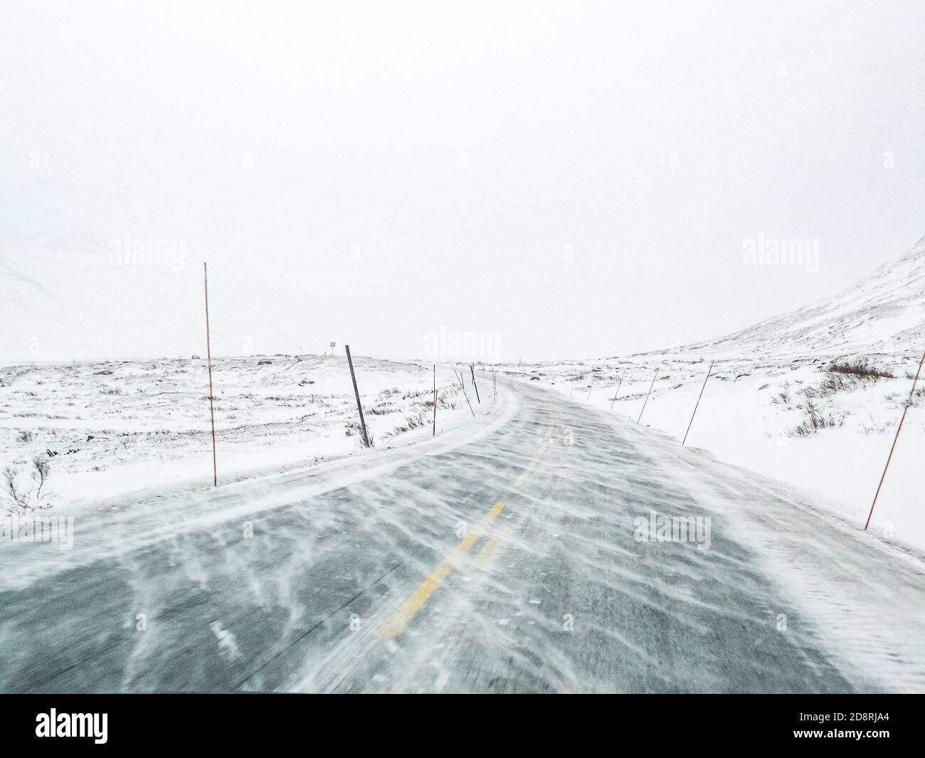 Driving through blizzard snowstorm on black ice and snowy white road ...