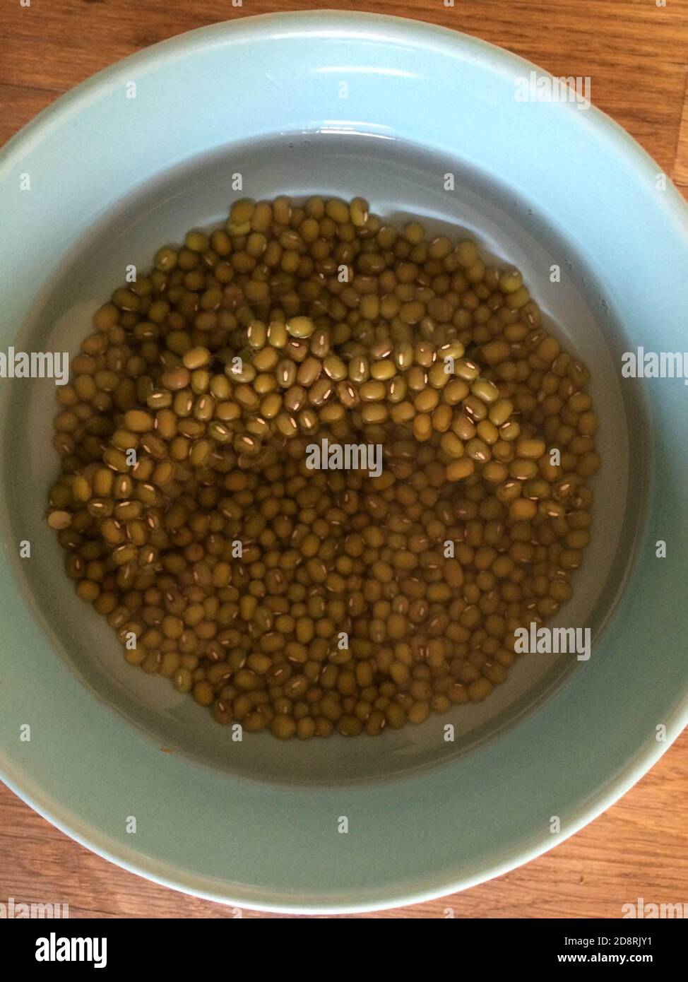 brown lentils soaking in water in a white bowl in the kitchen Stock ...