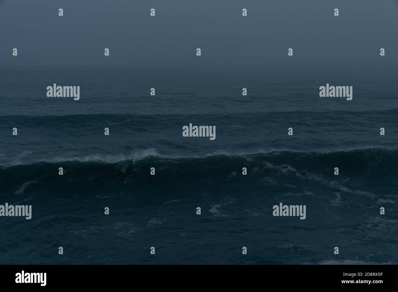 Detail view of large waves breaking in the open ocean at night during a ...