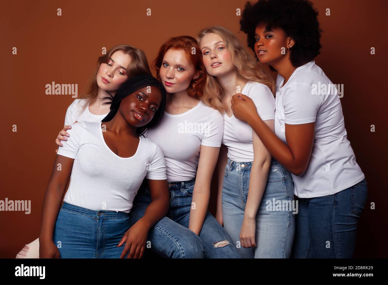 young pretty caucasian, afro, scandinavian woman posing cheerful together on brown background ...