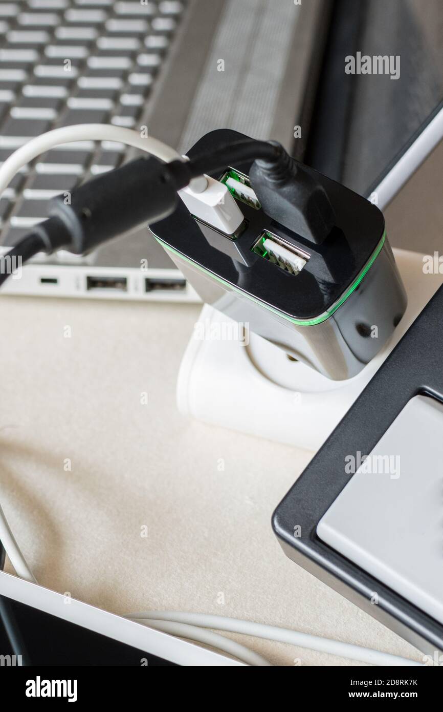 Electrical USB charger plug for four USB cable on a desk. Battery ...