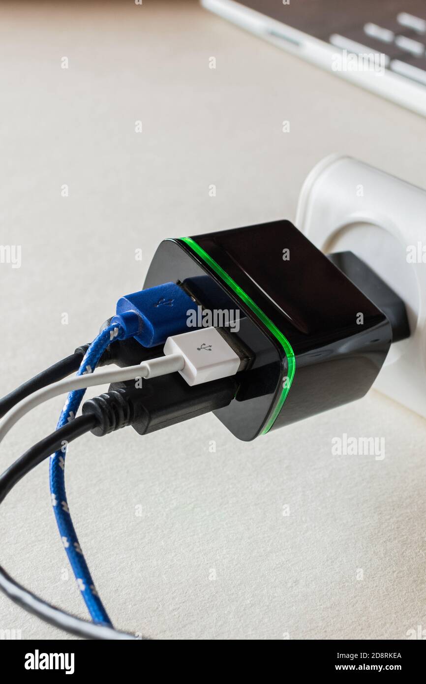 Electrical USB charger plug for four USB cable on a desk. Battery ...