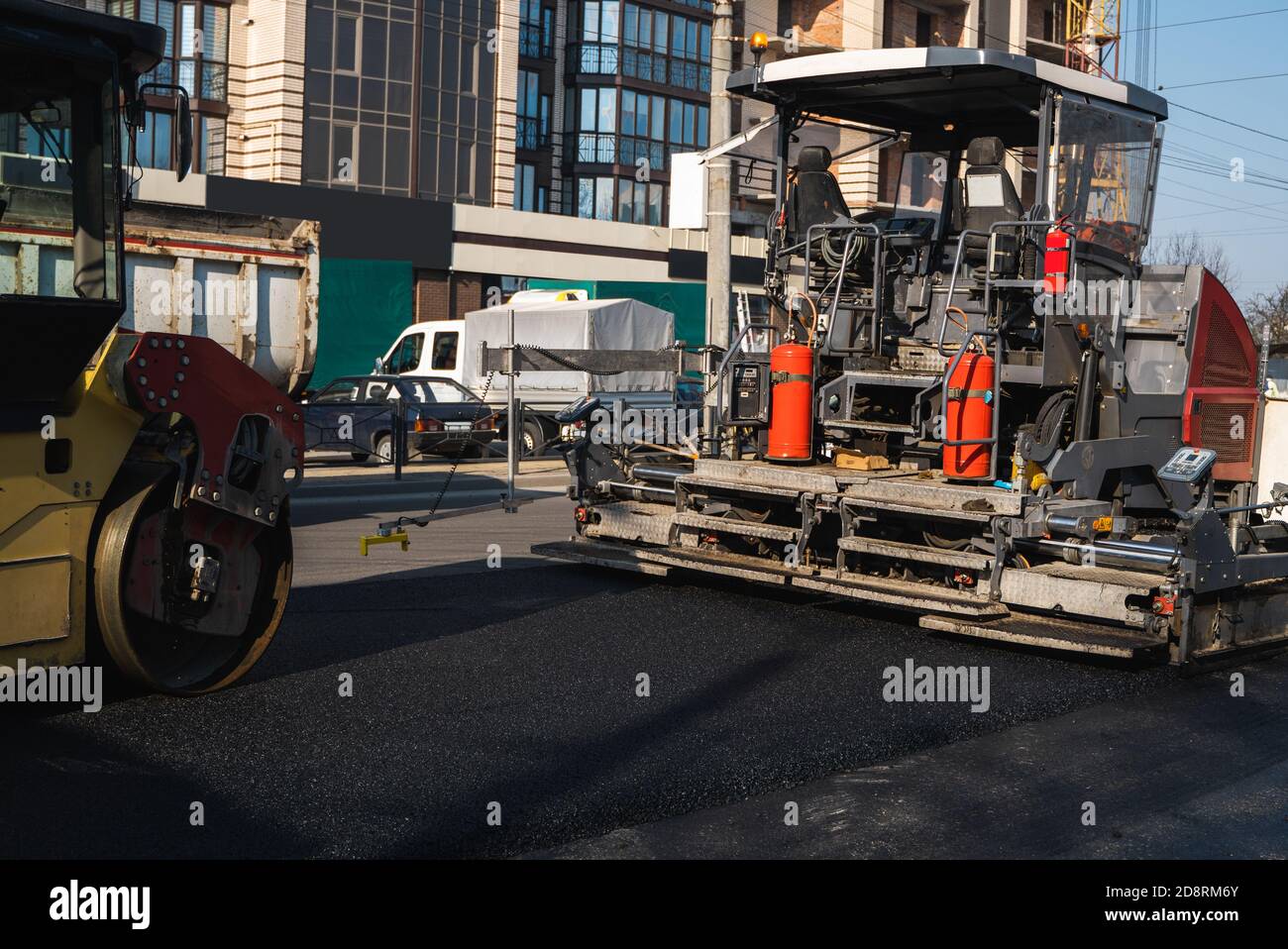 Industrial asphalt paver machine laying fresh asphalt and a Heavy road ...