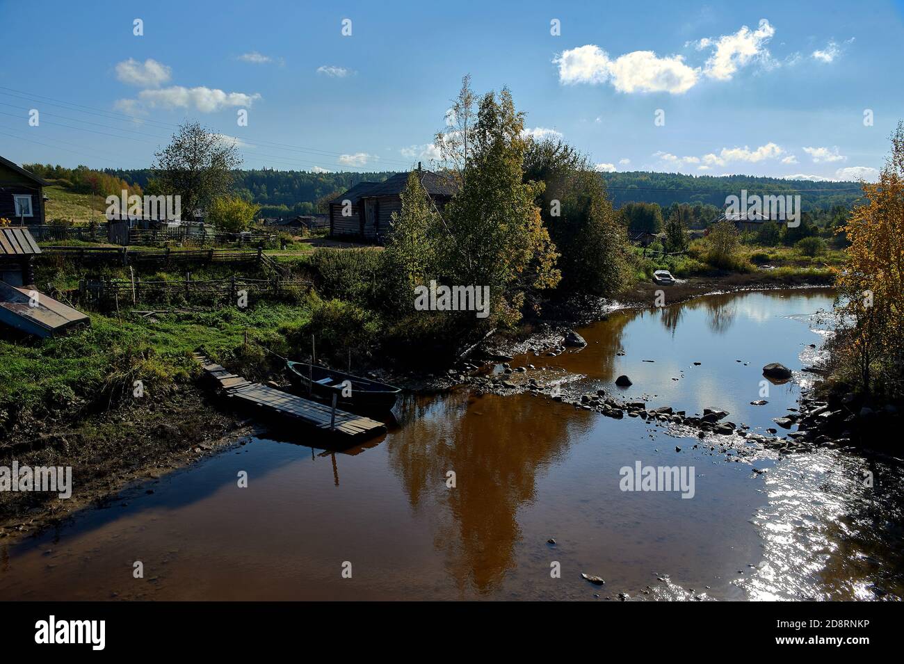 Shallow river on the background of the village Stock Photo - Alamy