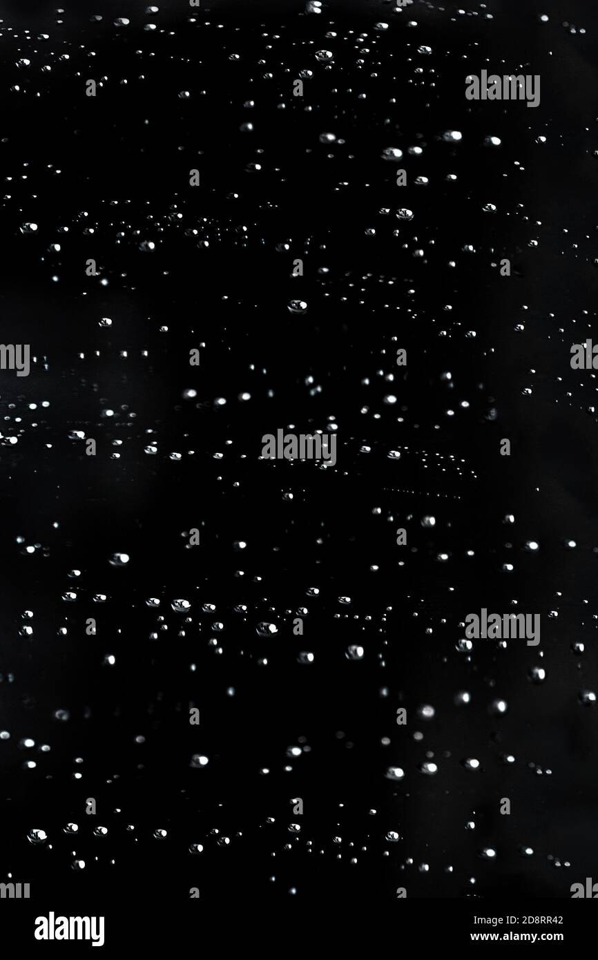 Falling Rain water drops on a black dramatic window glass. Autumn ...