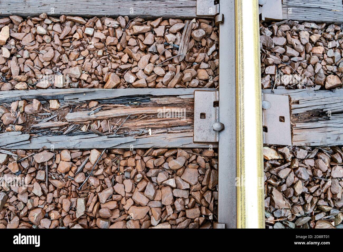 A damaged railway tie. The tie is inder a railway track and mostly ...