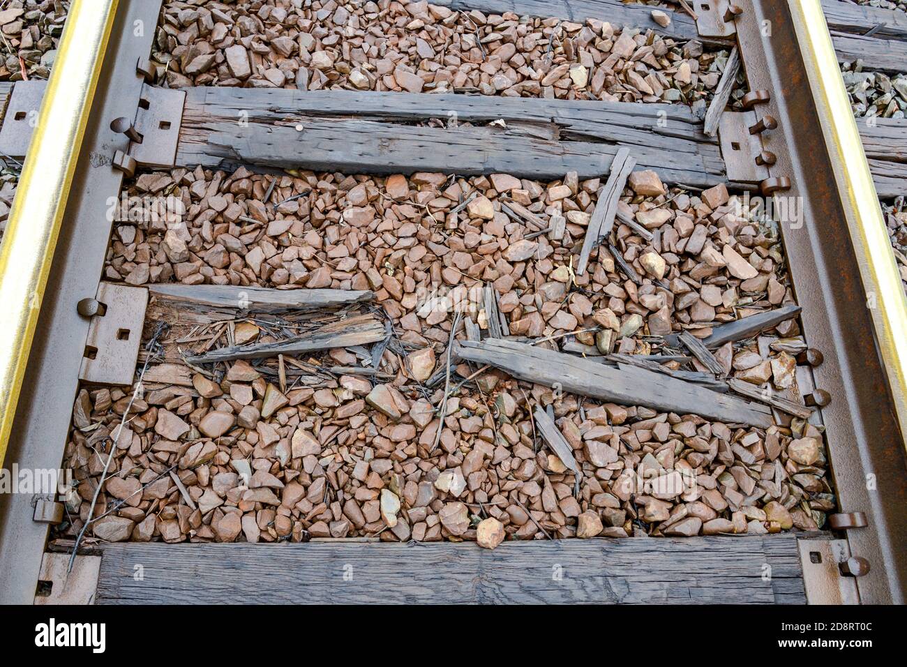 A damaged railway tie. The tie is inder railway tracks and completely ...