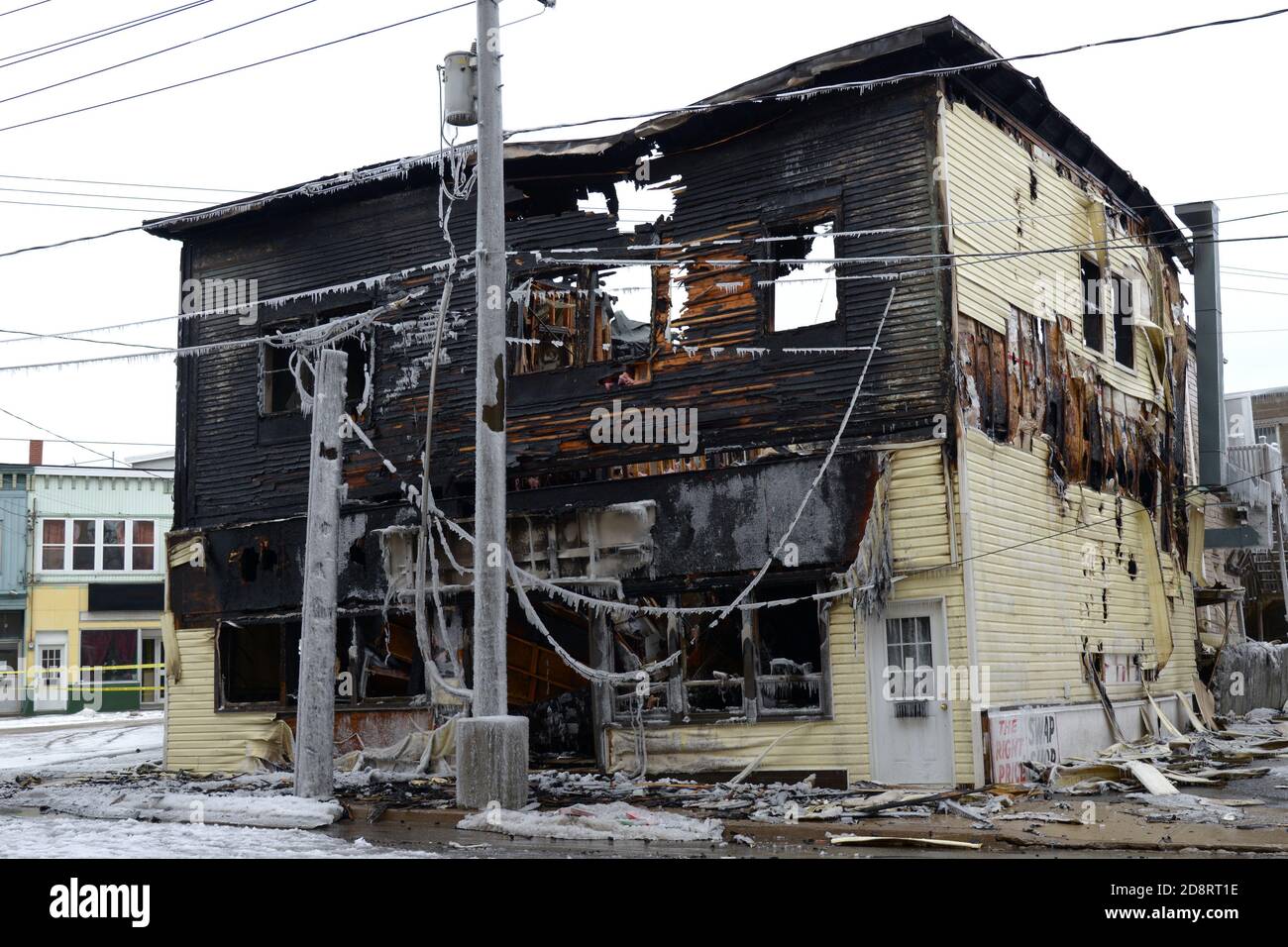 A burned building on a street corner in winter. The building is ...