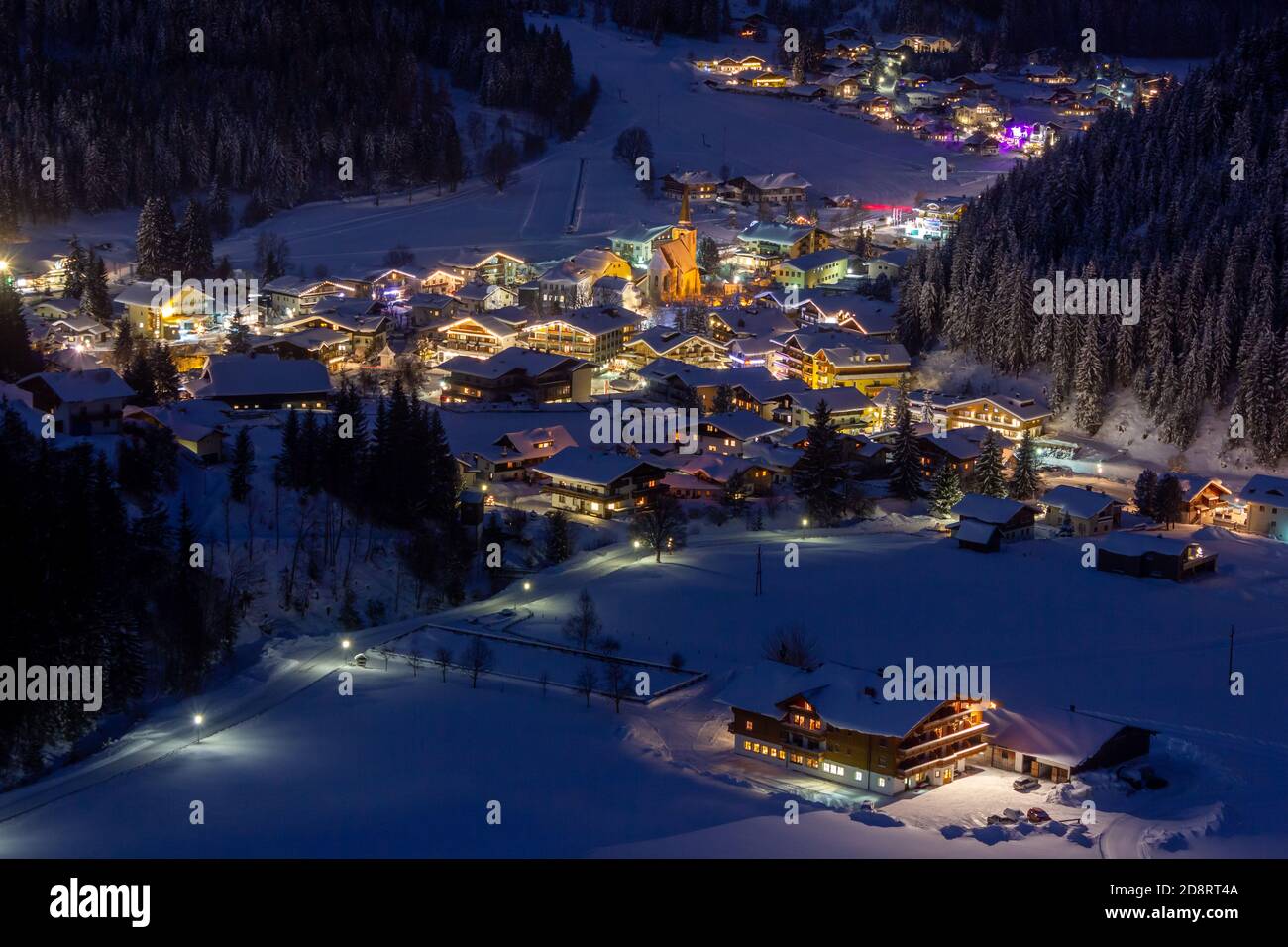 Aerial view of Austrian ski resort town at night during Winter ...