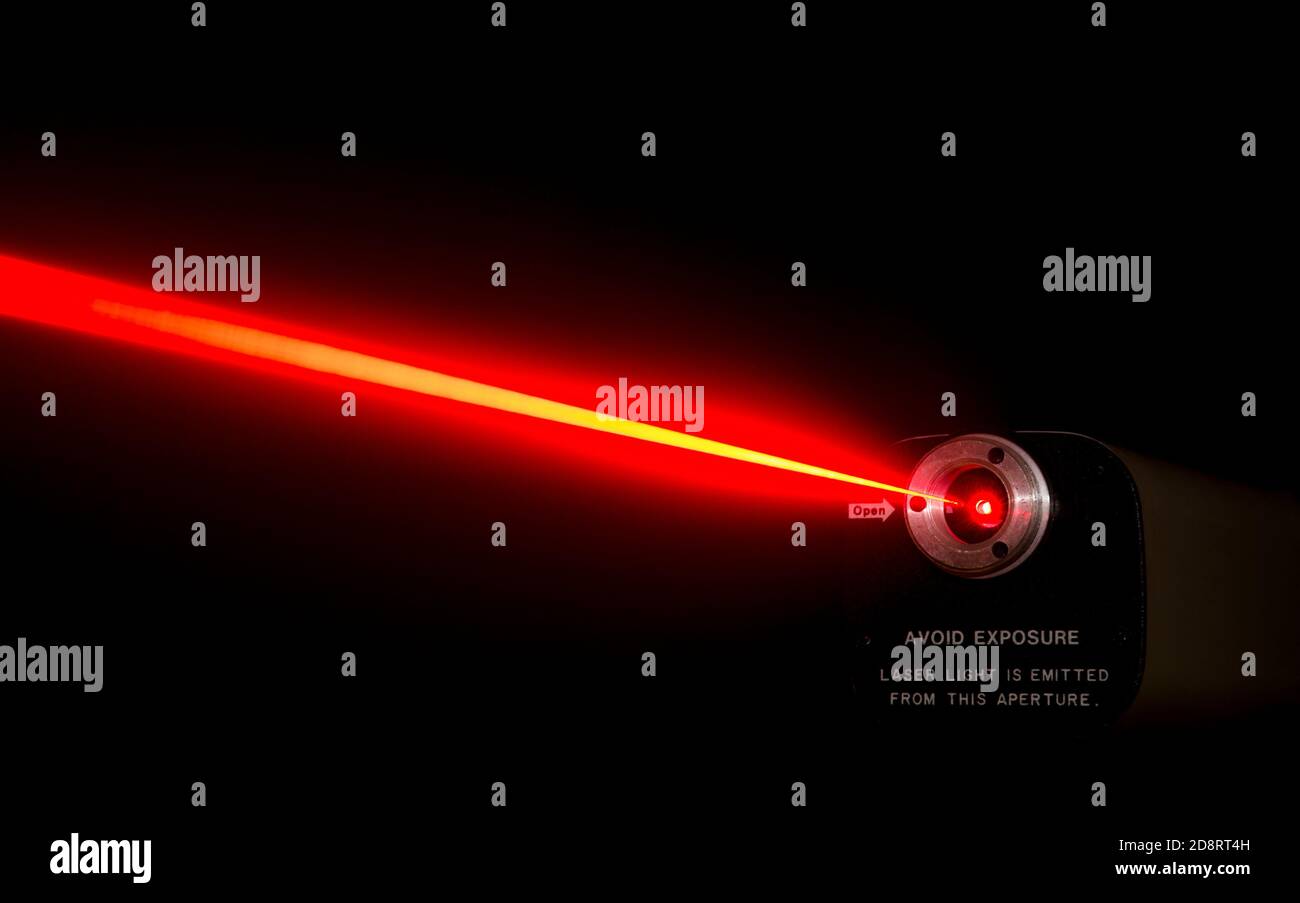 Red laser beam from a lab laser. Warning notice on front. Black ...