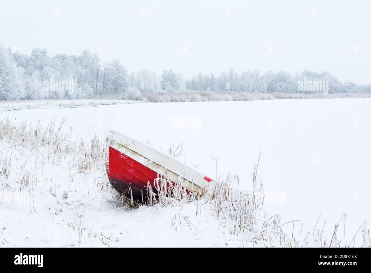 Snowy lake landscape with a row boat on the beach Stock Photo - Alamy