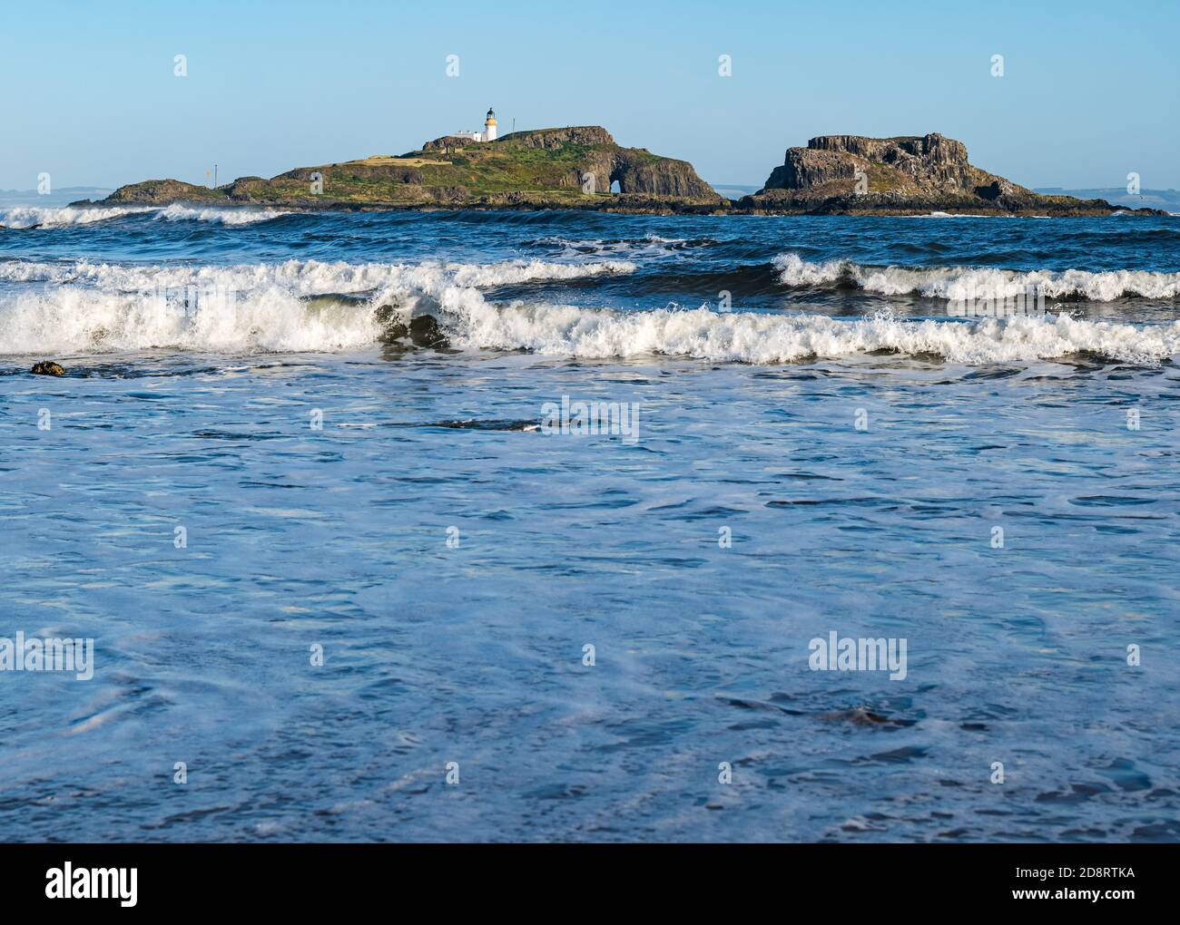 Fidra island and lighthouse on sunny day with waves, Yellowcraig beach ...