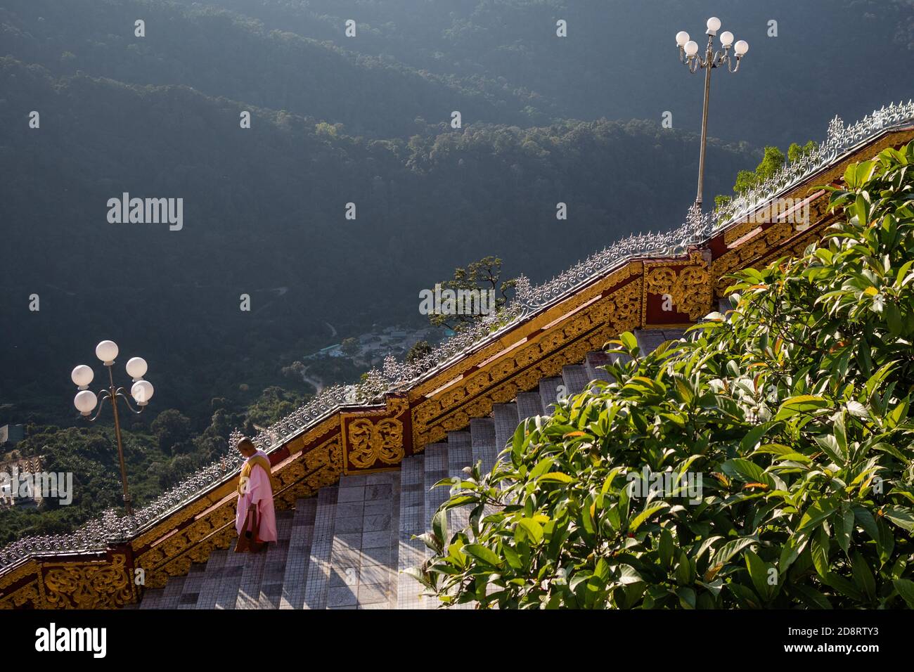 Female buddhist monk walking down the stairs. Nun wears traditional ...