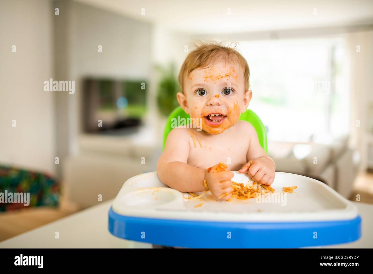 A Little baby eating her dinner and making a mess Stock Photo - Alamy
