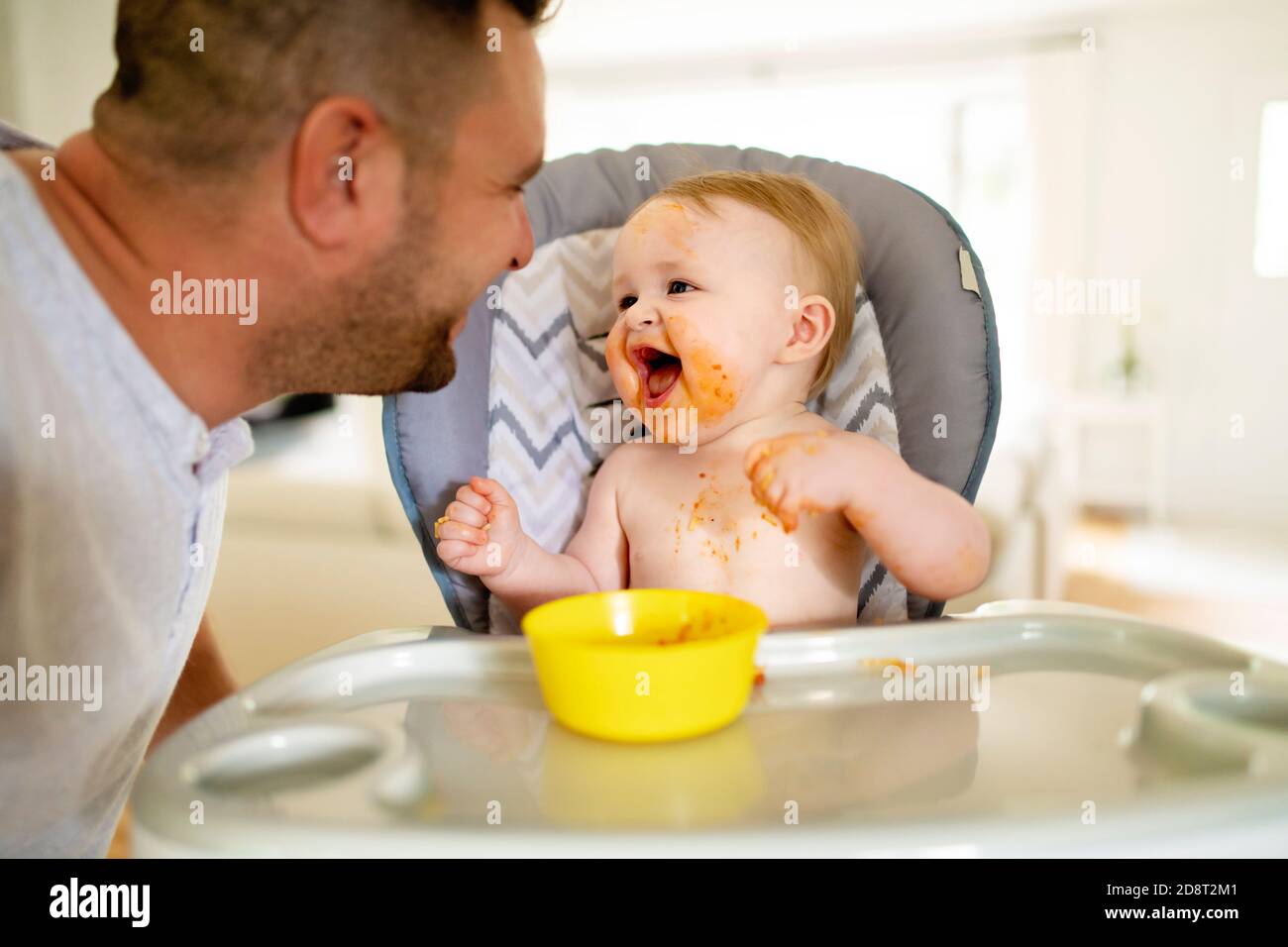 A Little baby eating her dinner and making a mess with dad on the side ...