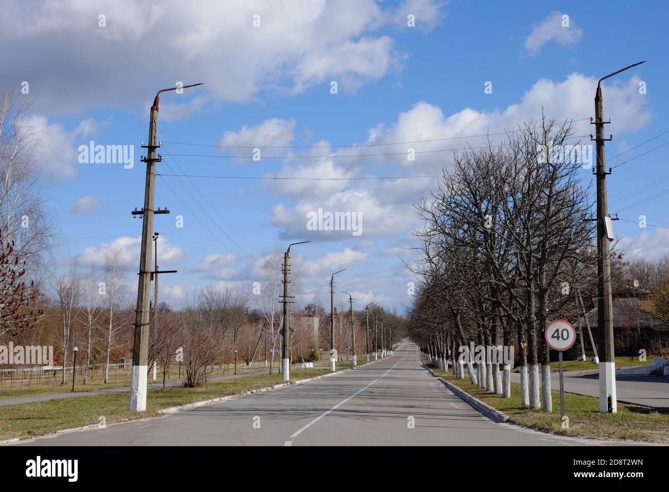Long straight road. Lamp posts along the road. Beautiful cloudy sky ...