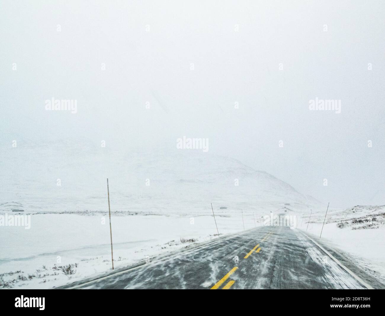Driving through blizzard snowstorm on black ice and snowy white road ...